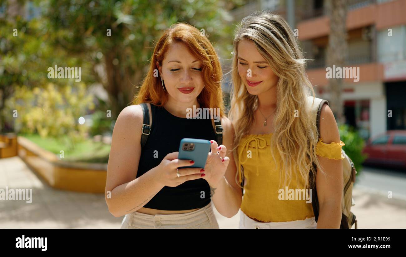 Two women standing together using hi-res stock photography and images ...