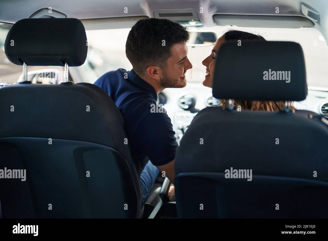 Young hispanic couple driving car kissing at street Stock Photo - Alamy