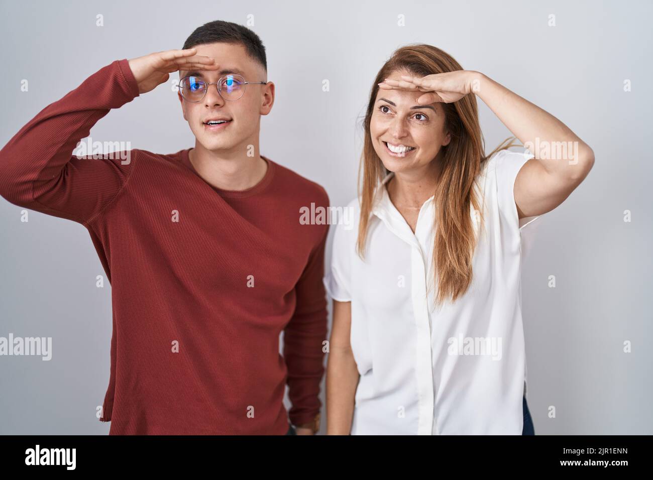 Mother and son standing together over isolated background very happy ...
