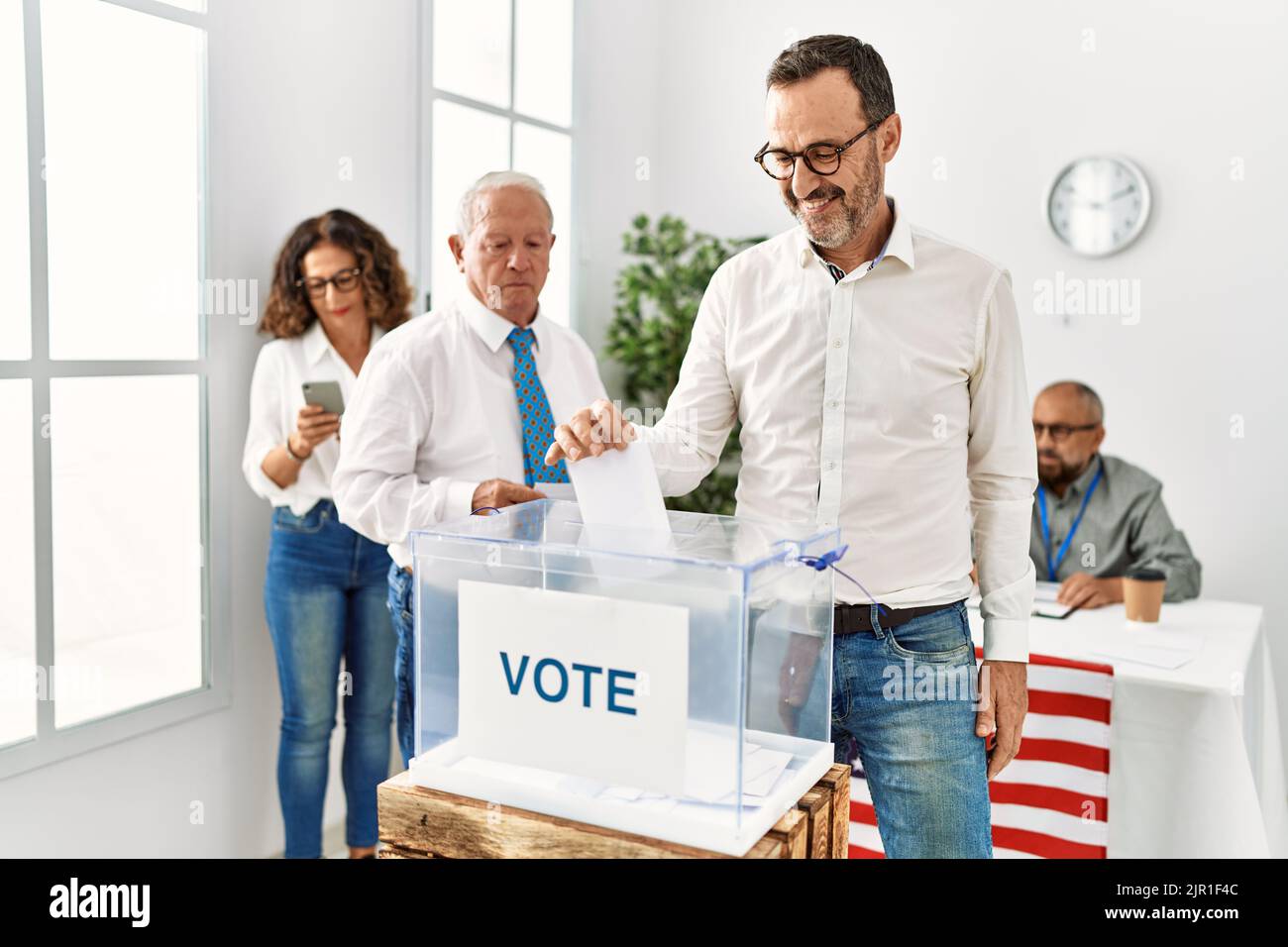 Middle age american voter man smiling happy putting ballot in voting ...