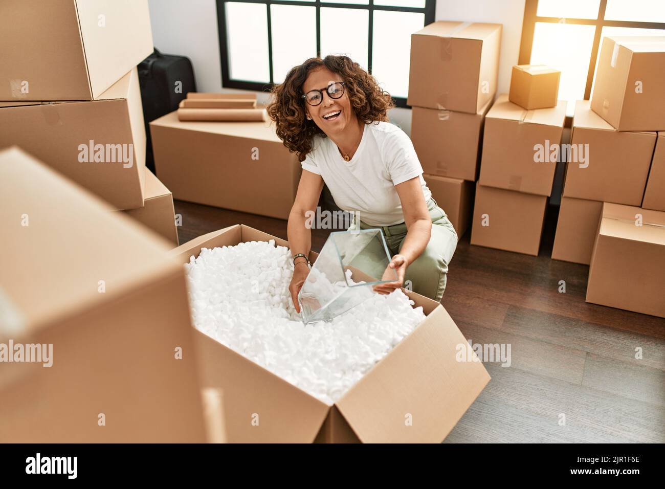 Middle age hispanic woman smiling confident moving at new home Stock ...