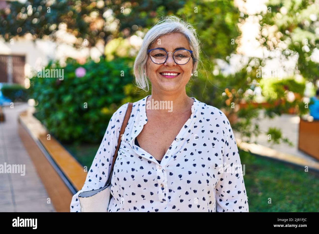 Middle age woman smiling confident standing at park Stock Photo - Alamy