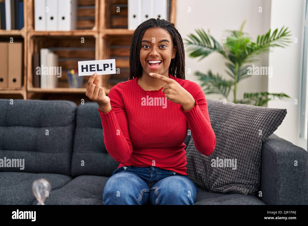 Young african american with braids doing therapy holding help banner ...