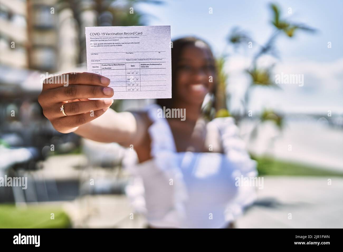 Young african american girl smiling happy holding covid-19 vaccination ...