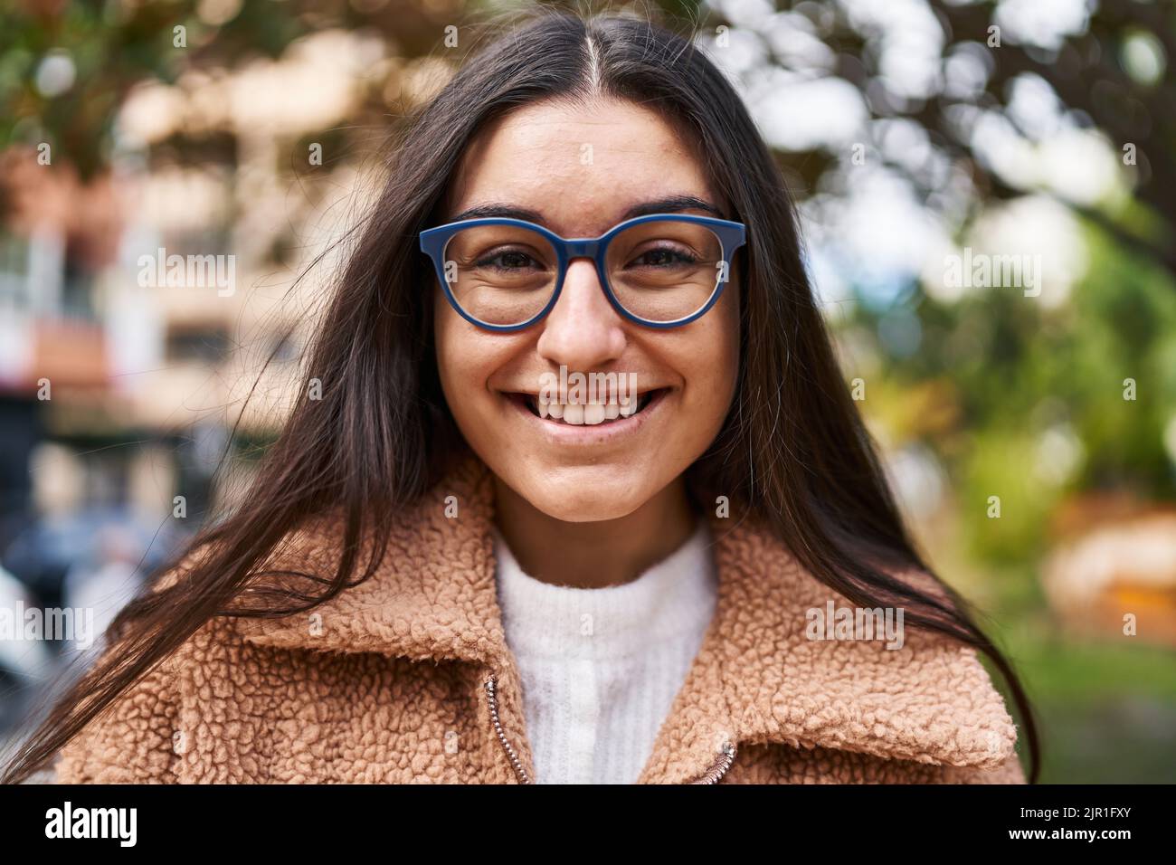 Young hispanic woman smiling confident standing at park Stock Photo - Alamy
