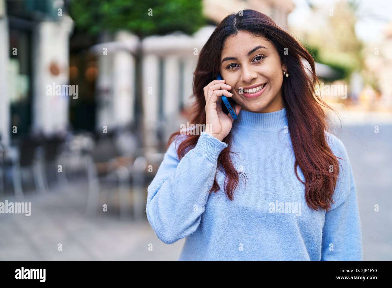 Young hispanic woman smiling confident talking on the smartphone at ...