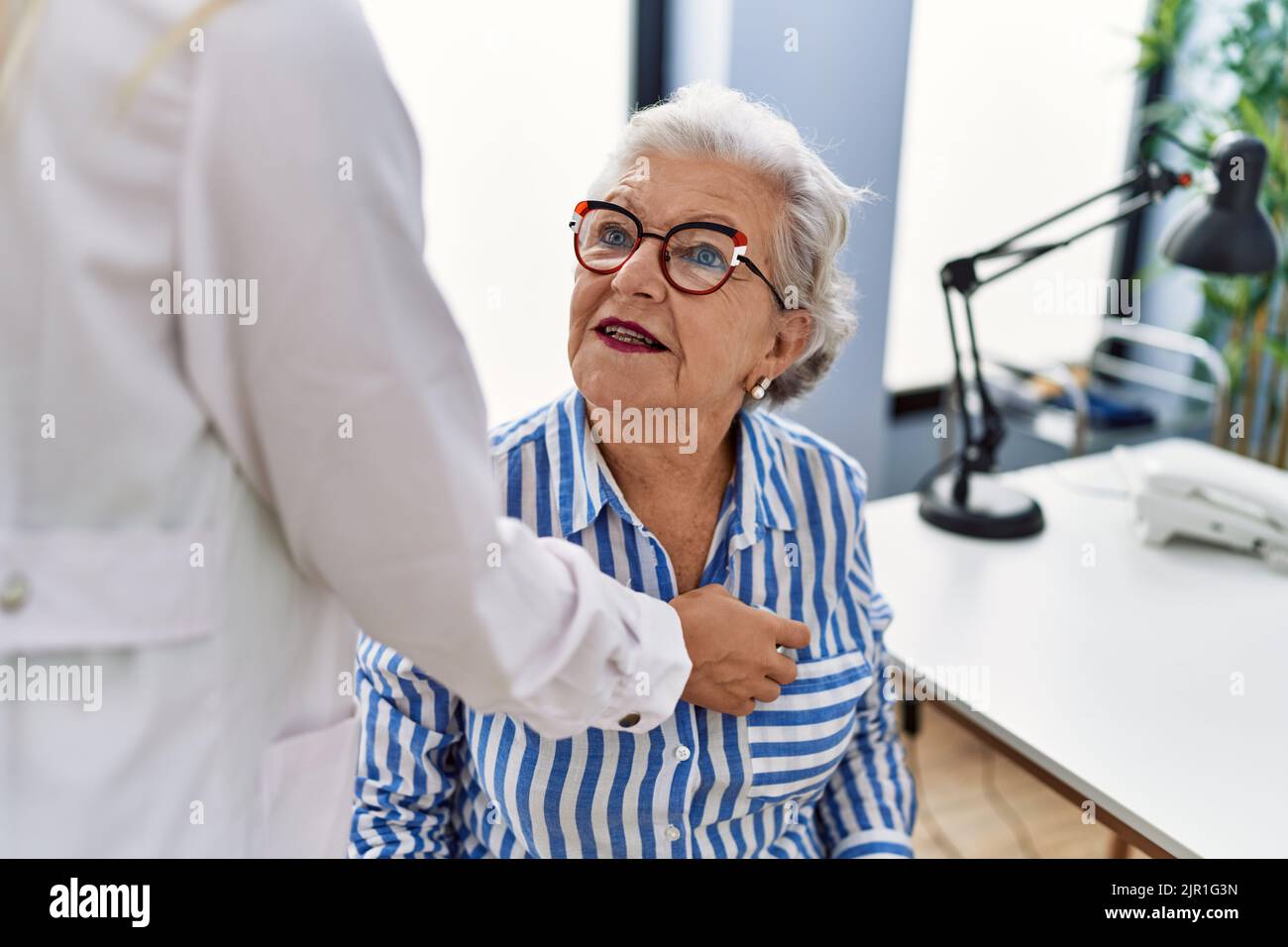 Senior grey-haired woman patient having medical consultation ...