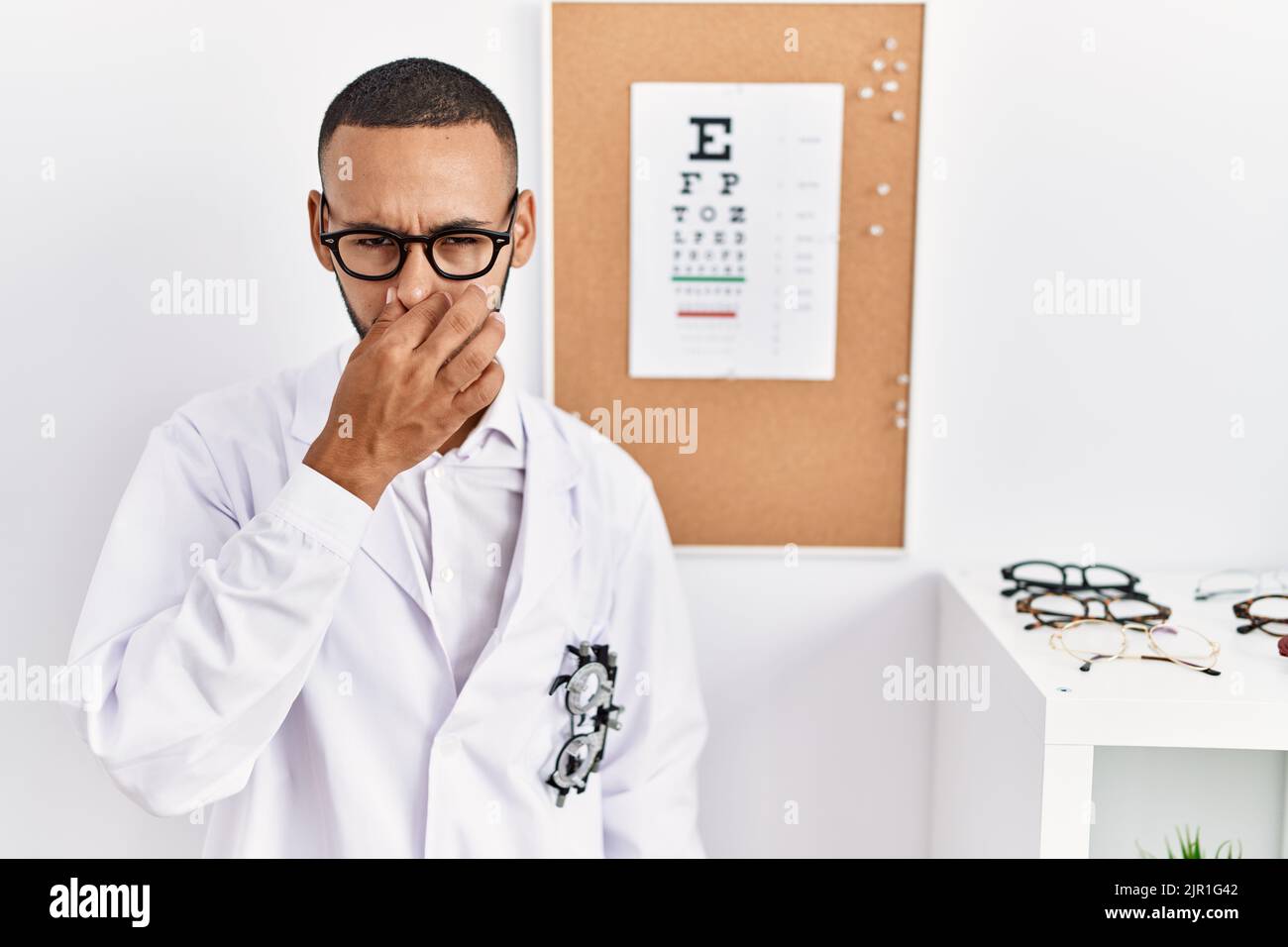 African american optician man standing by eyesight test smelling ...