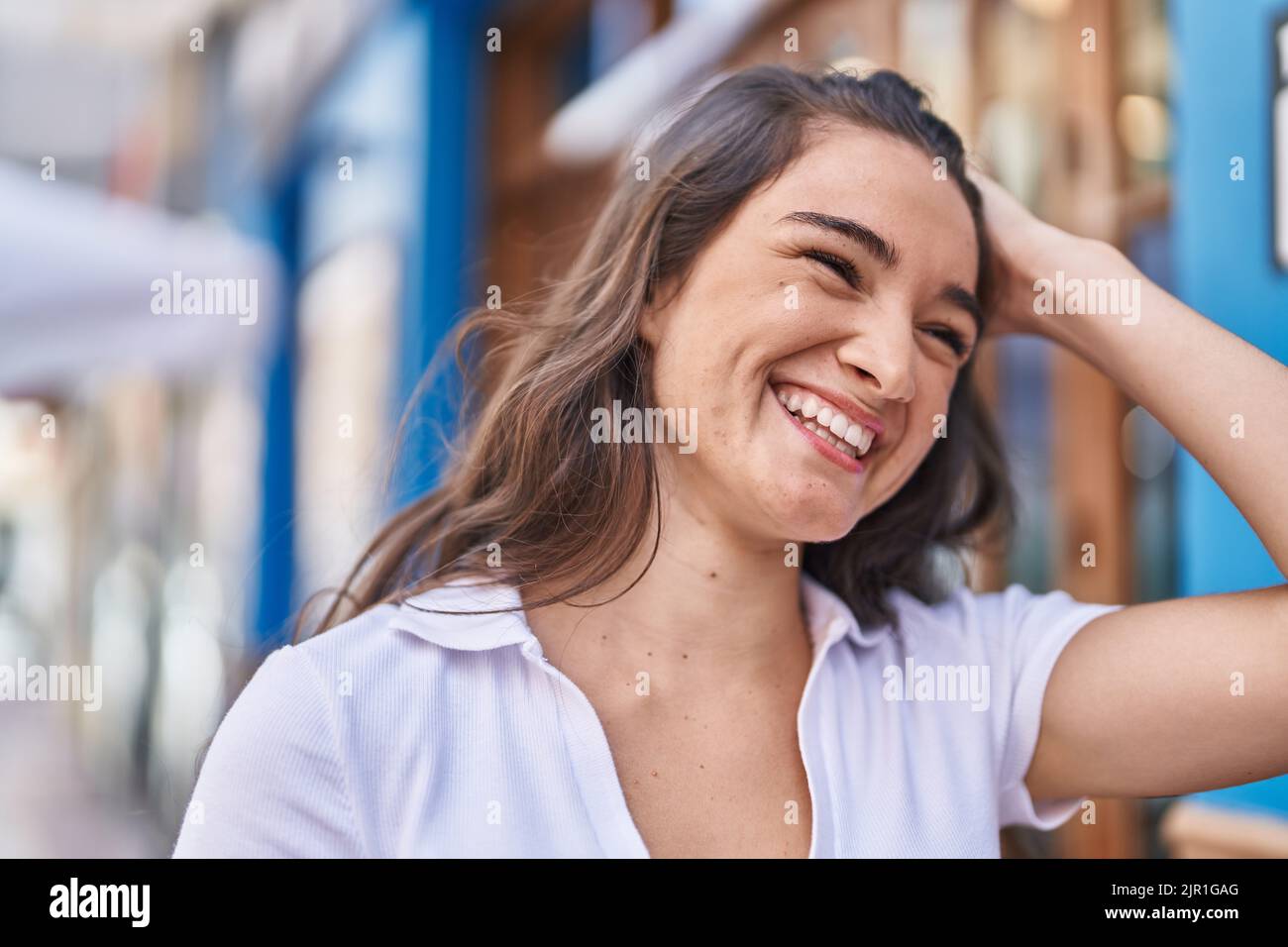 Young hispanic woman smiling confident looking to the side at street ...