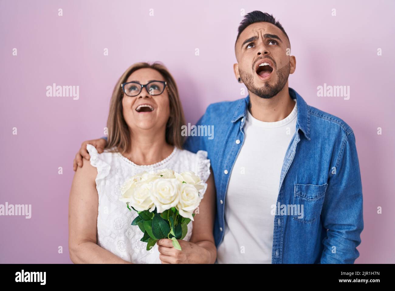 Hispanic mother and son together holding bouquet of white flowers angry ...