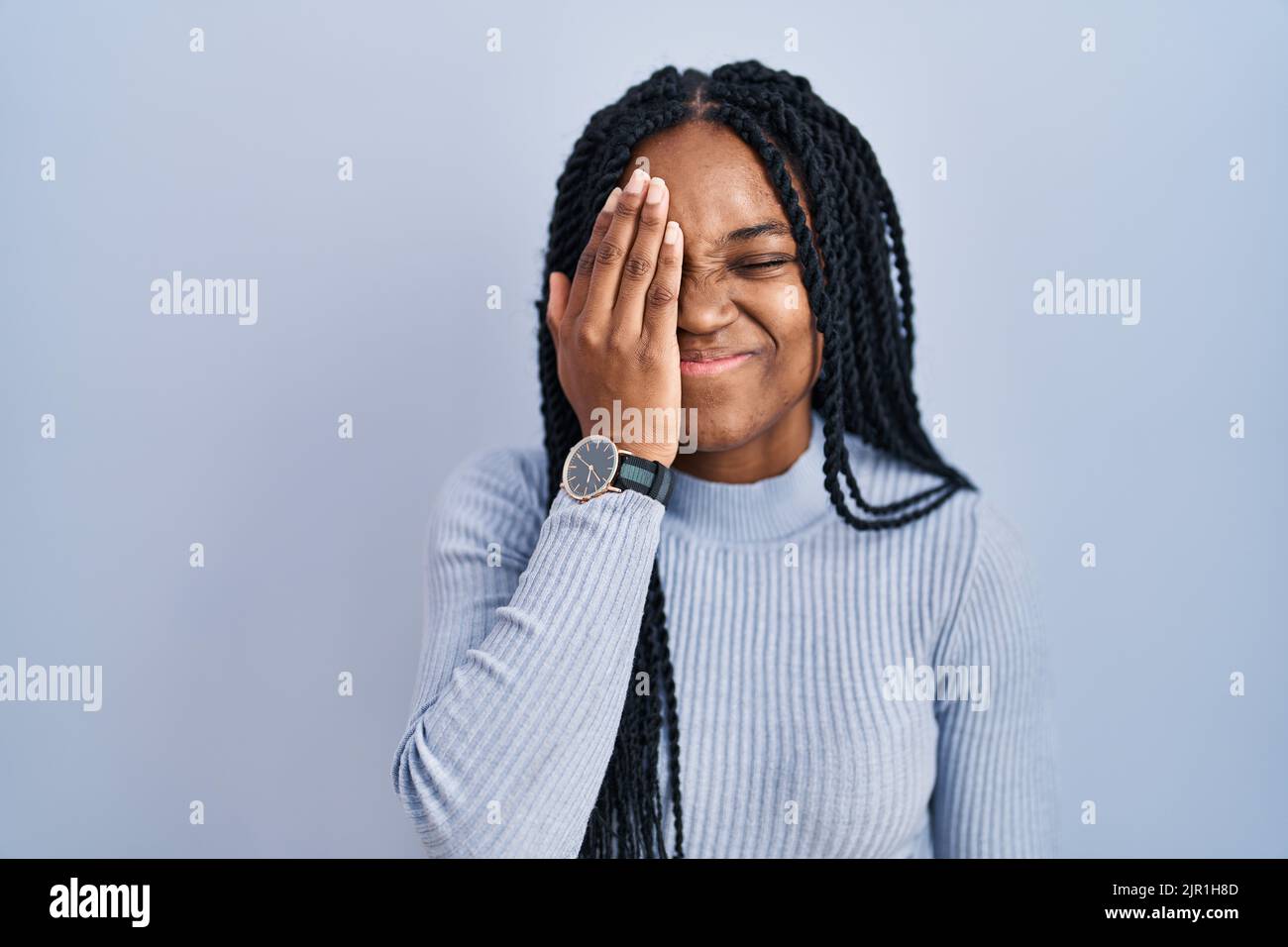 African american woman standing over blue background yawning tired ...