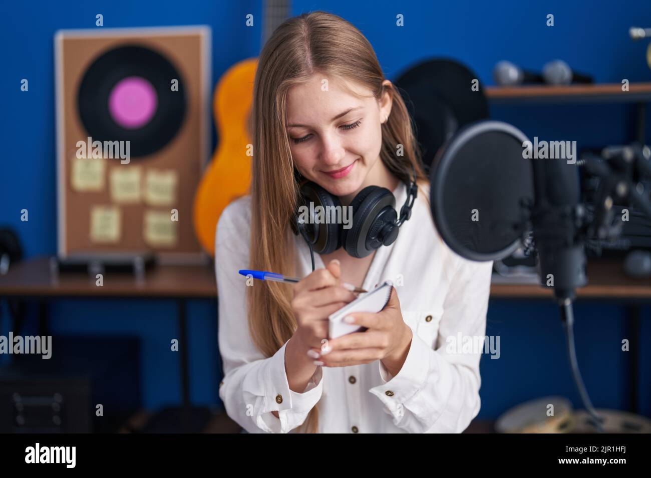 Young caucasian woman artist smiling confident composing song at music ...