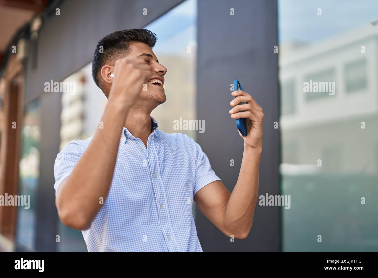 Young hispanic man smiling confident using smartphone at street Stock ...