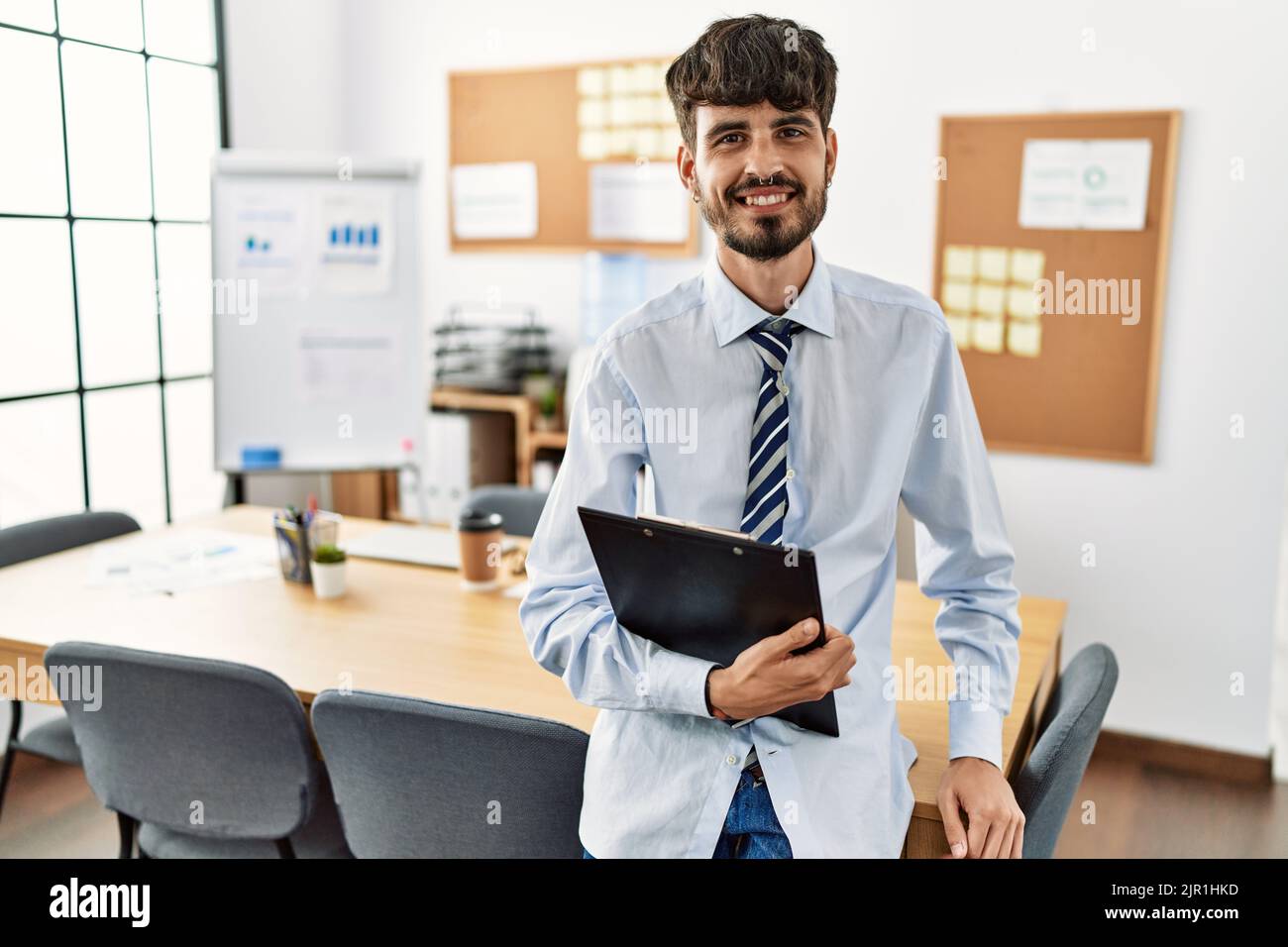 Young hispanic businessman smiling happy working at the office Stock ...