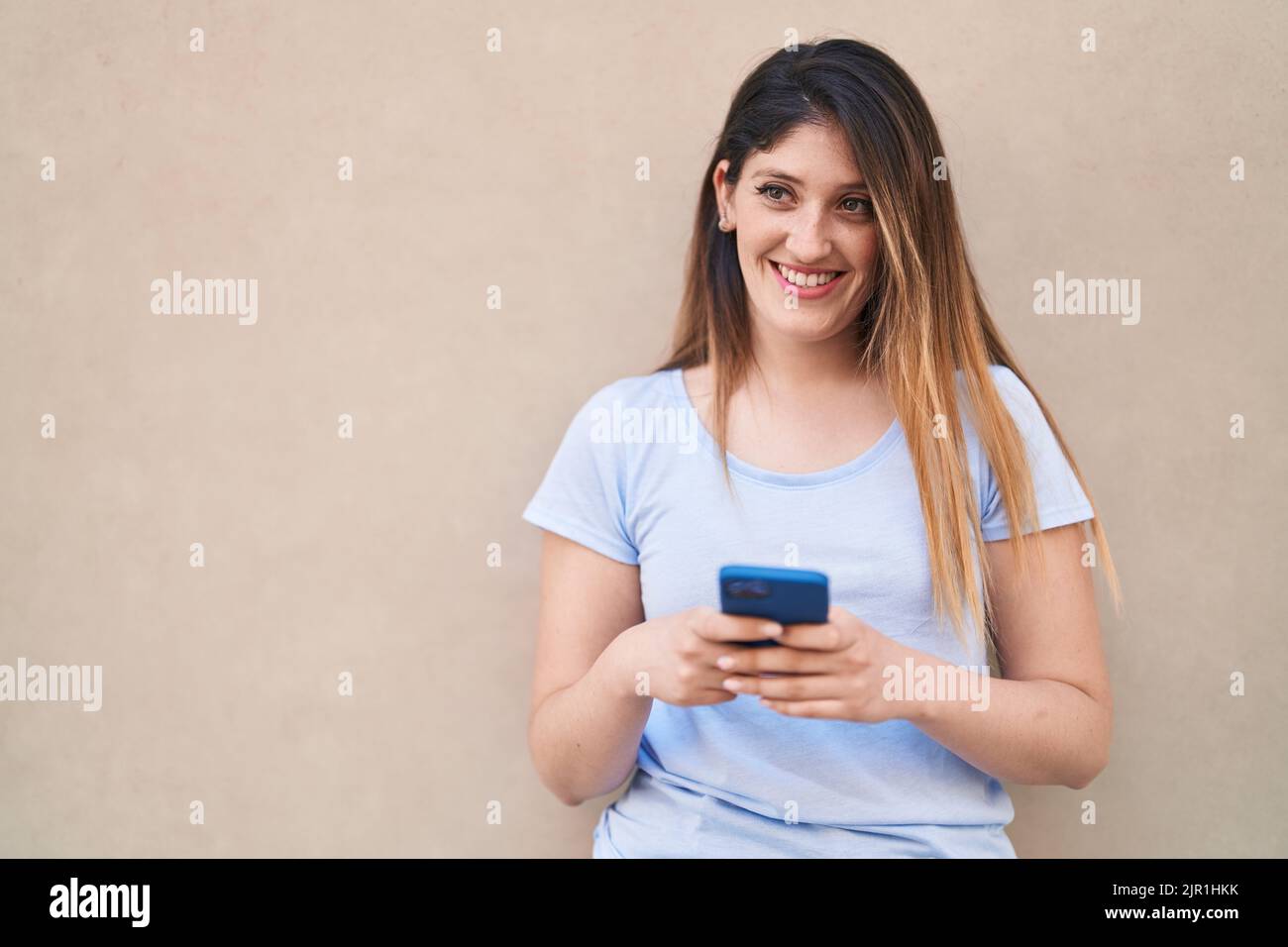 Young hispanic woman smiling confident using smartphone over isolated ...