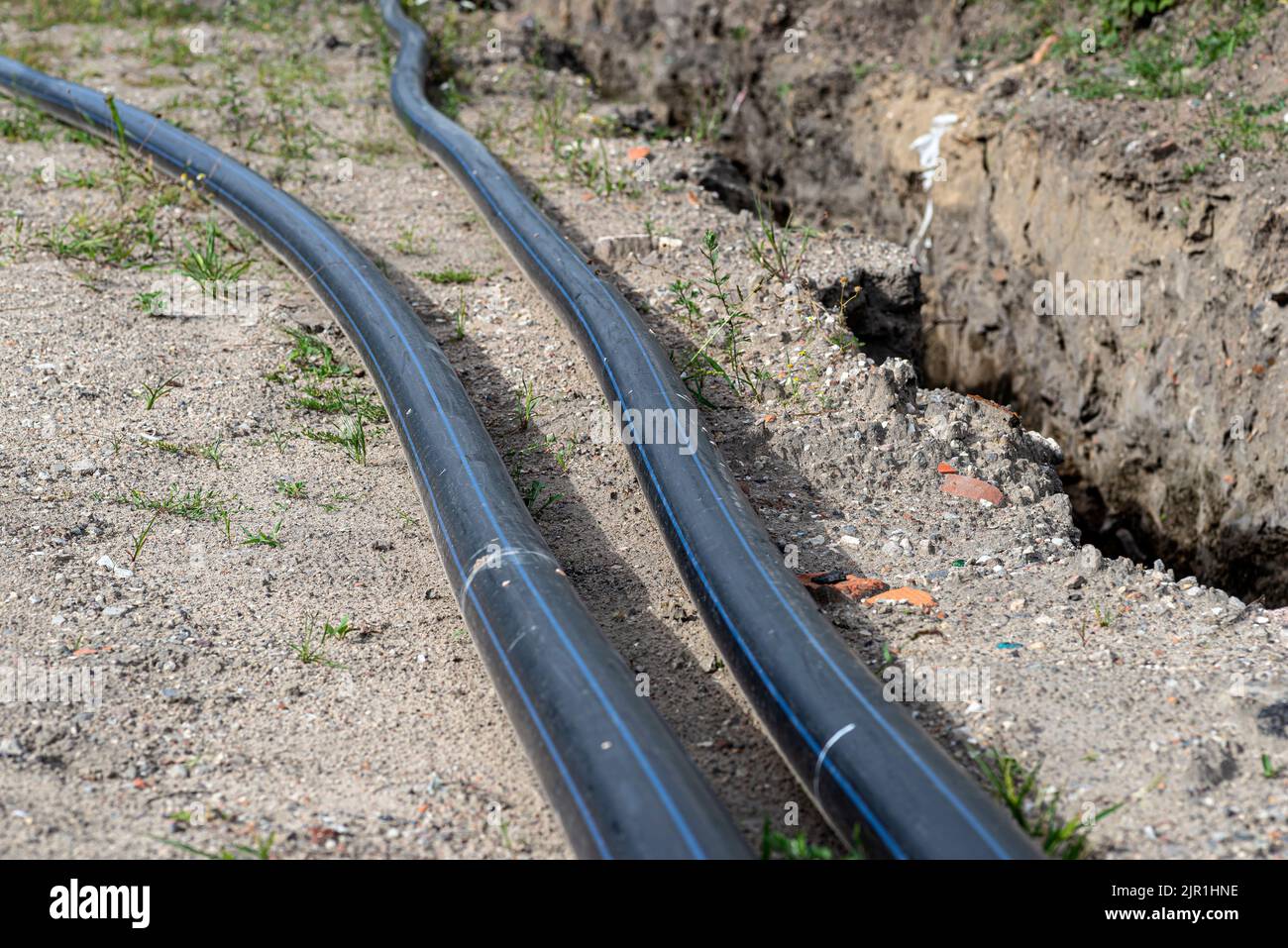 Plastic water pipe lying along the ditch with high groundwater, water ...