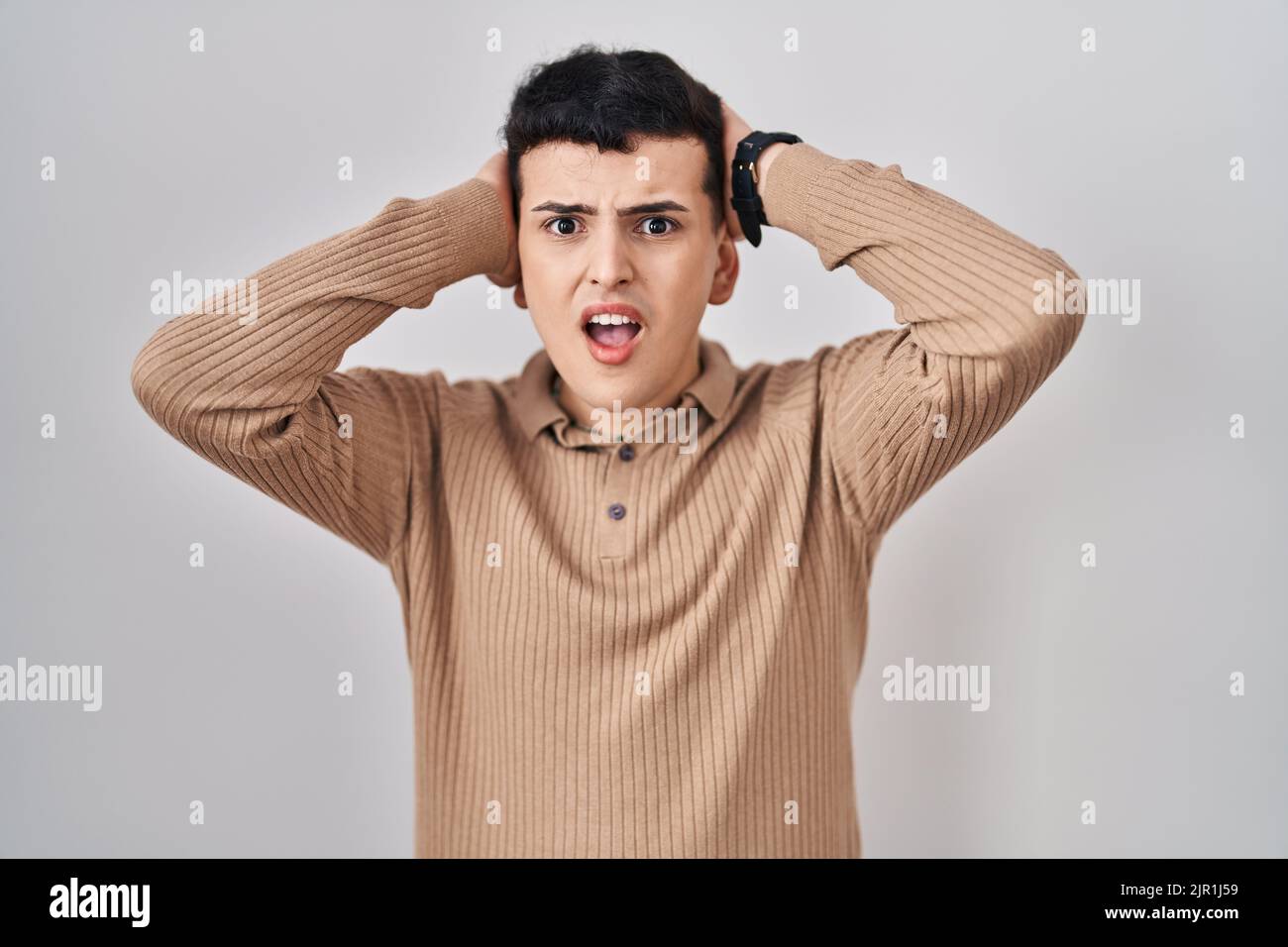 Non binary person standing over isolated background crazy and scared ...