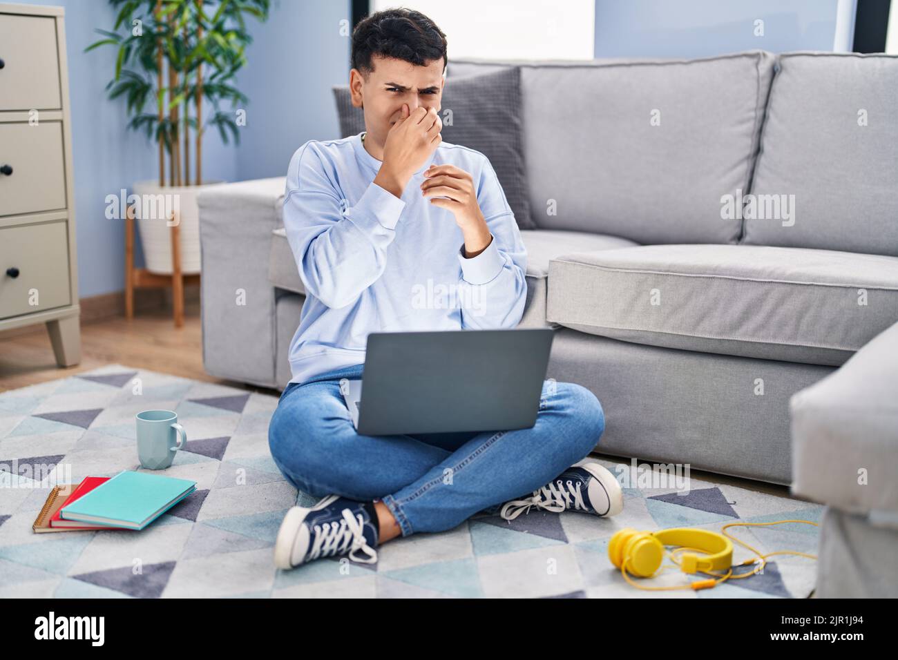 Non binary person studying using computer laptop sitting on the floor ...