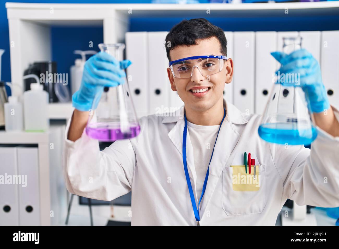 Young non binary man scientist smiling confident measuring liquid at laboratory Stock Photo - Alamy