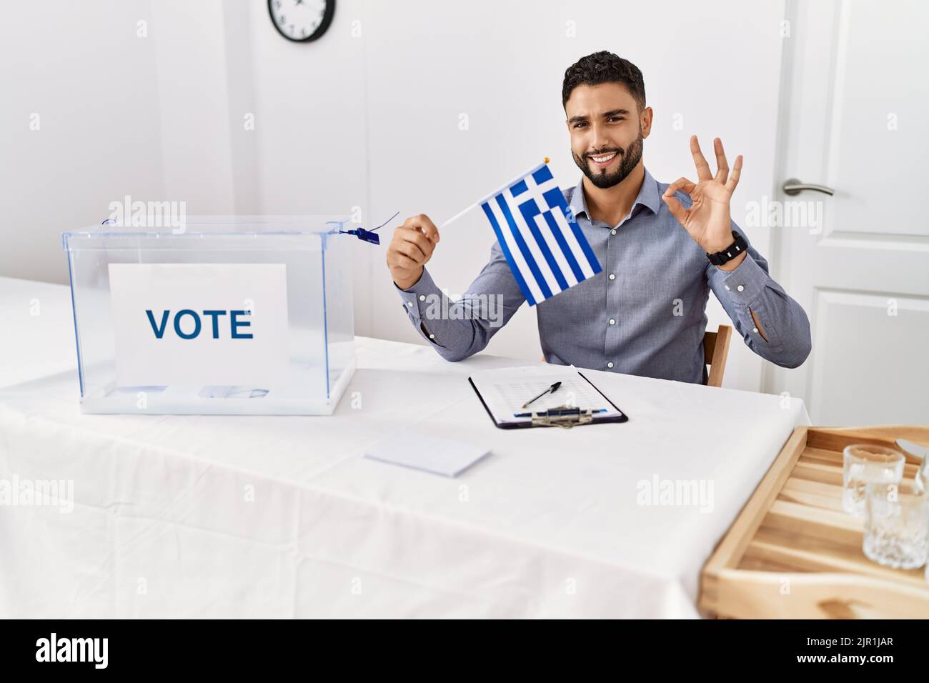 Young handsome man with beard at political campaign election holding ...