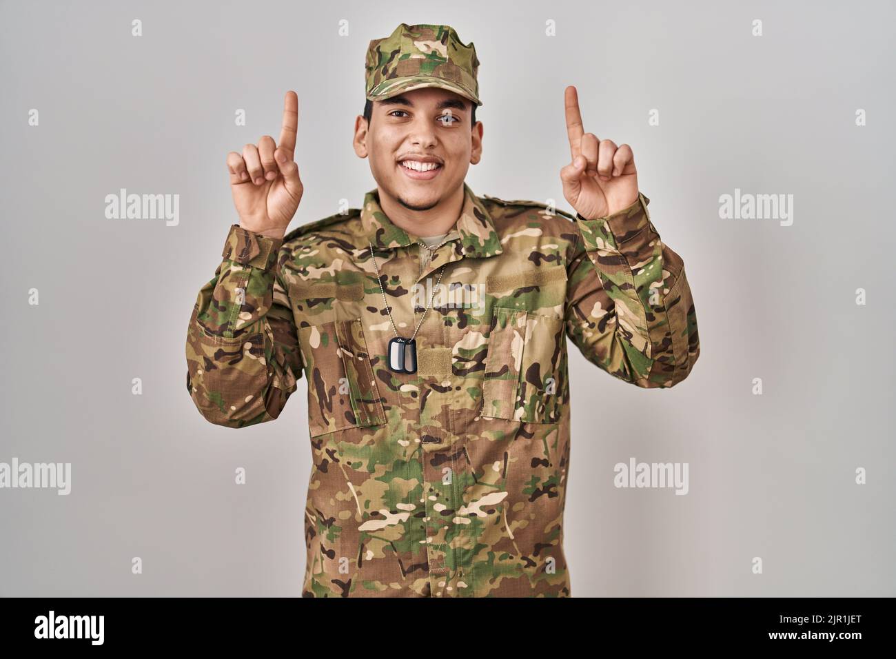 Young arab man wearing camouflage army uniform smiling amazed and ...