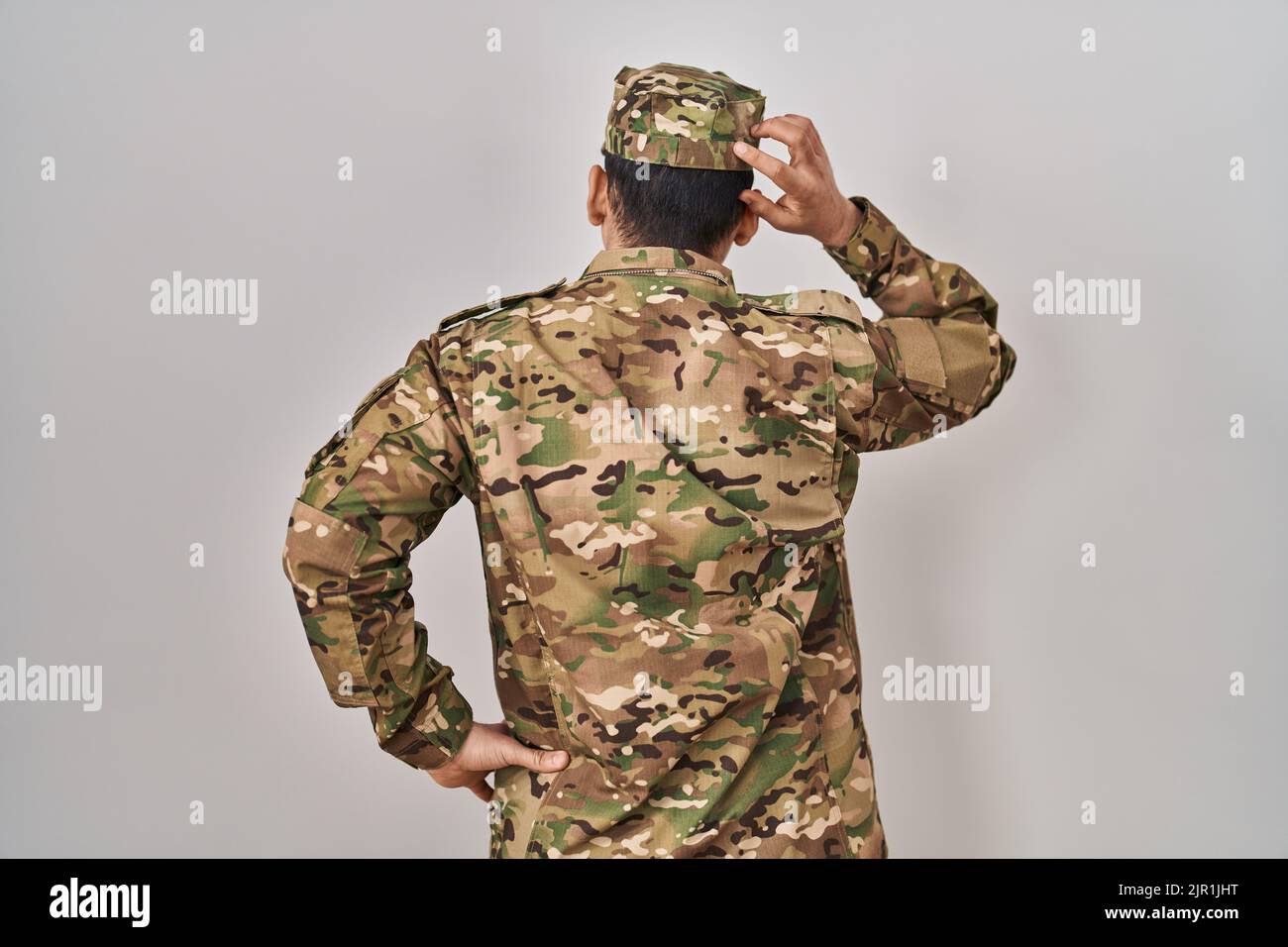 Young arab man wearing camouflage army uniform backwards thinking about ...