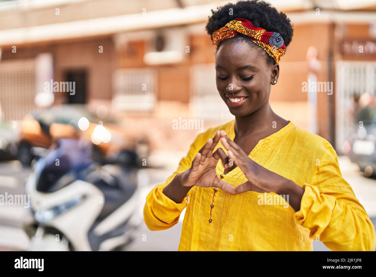 Young african american woman smiling confident doing heart symbol with ...
