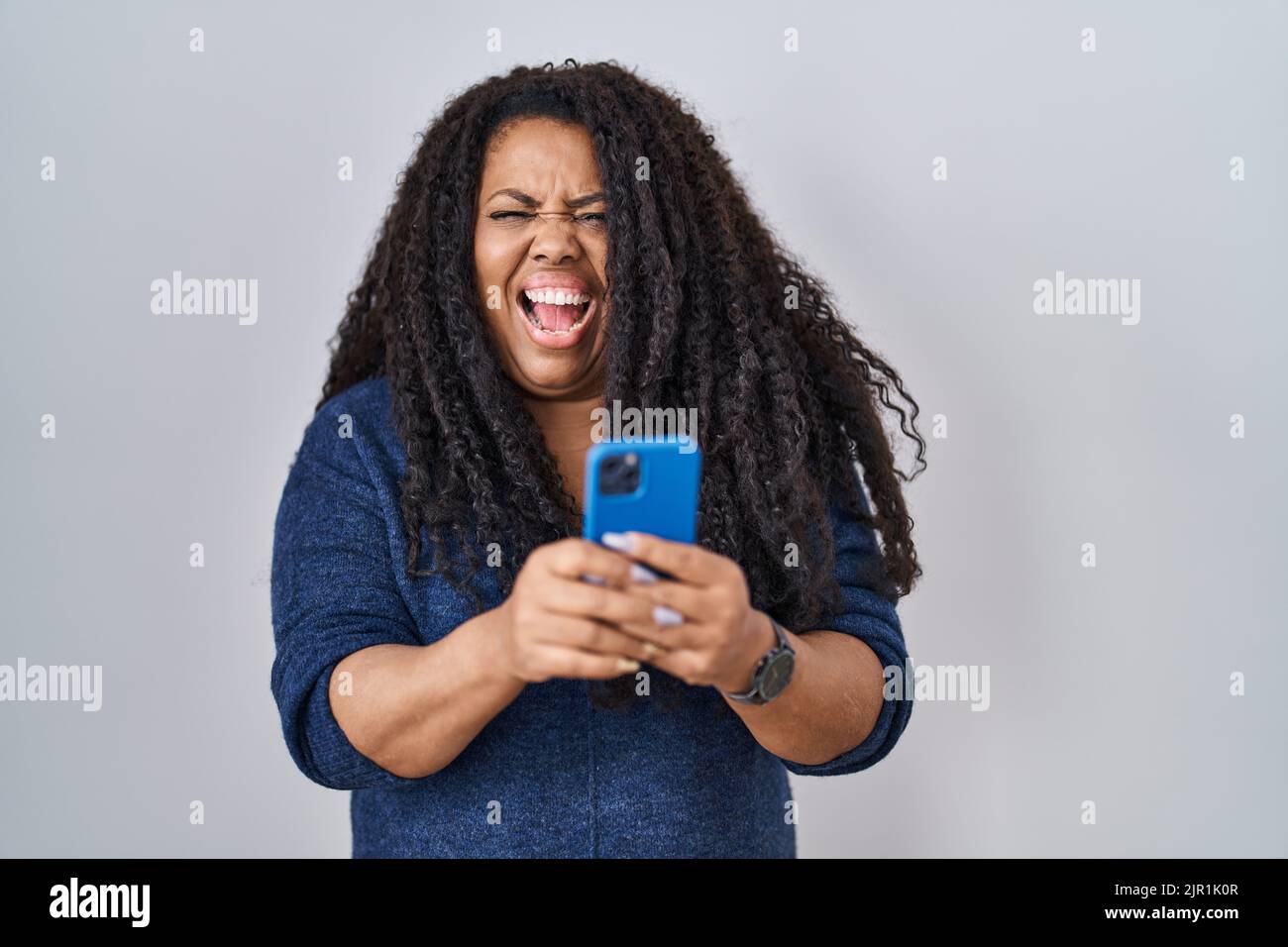 Plus size hispanic woman using smartphone typing message smiling and ...