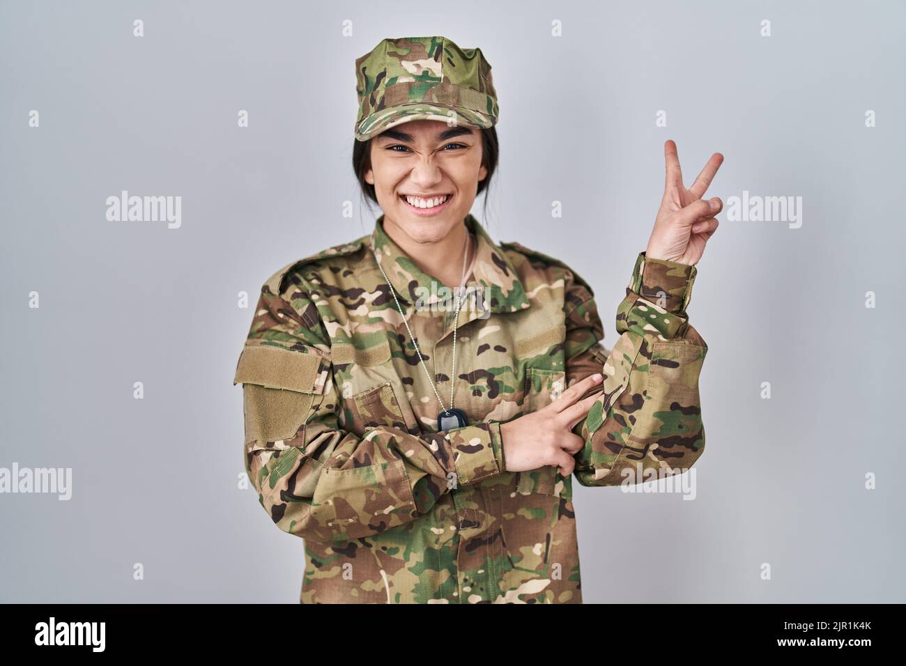 Young south asian woman wearing camouflage army uniform smiling with ...