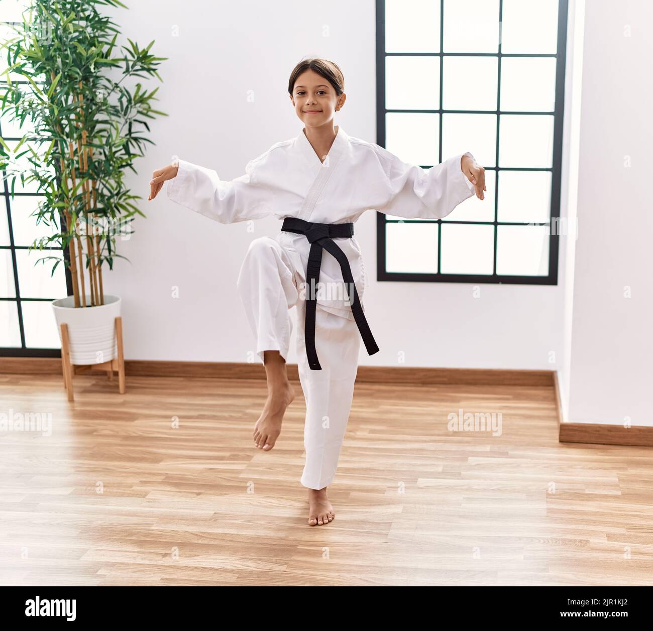 Young hispanic girl doing martial arts at training studio Stock Photo - Alamy