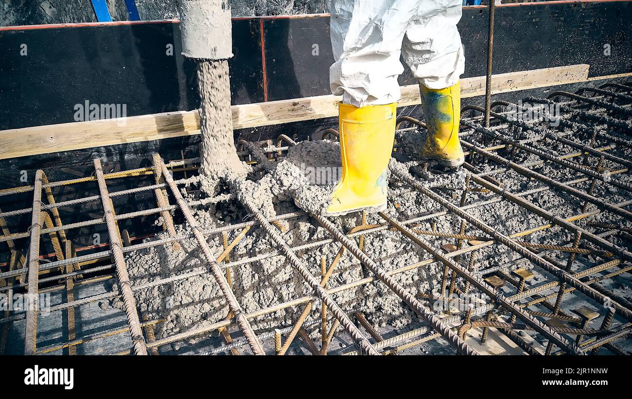 Construction worker is pouring concrete to formwork Stock Photo - Alamy