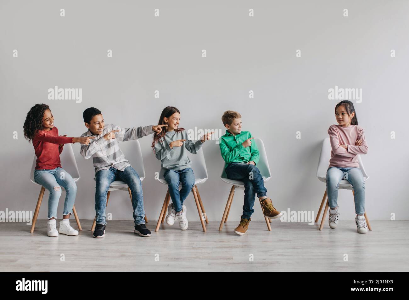 Preteen Kids Laughing Pointing At Victimized Asian Schoolgirl Sitting ...