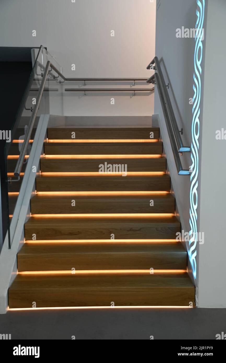 Contemporary wooden staircase with a stainless steel handrail and ...