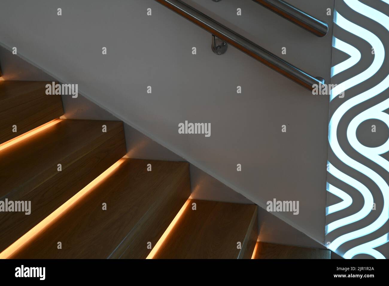 Contemporary wooden staircase with a stainless steel handrail and ...