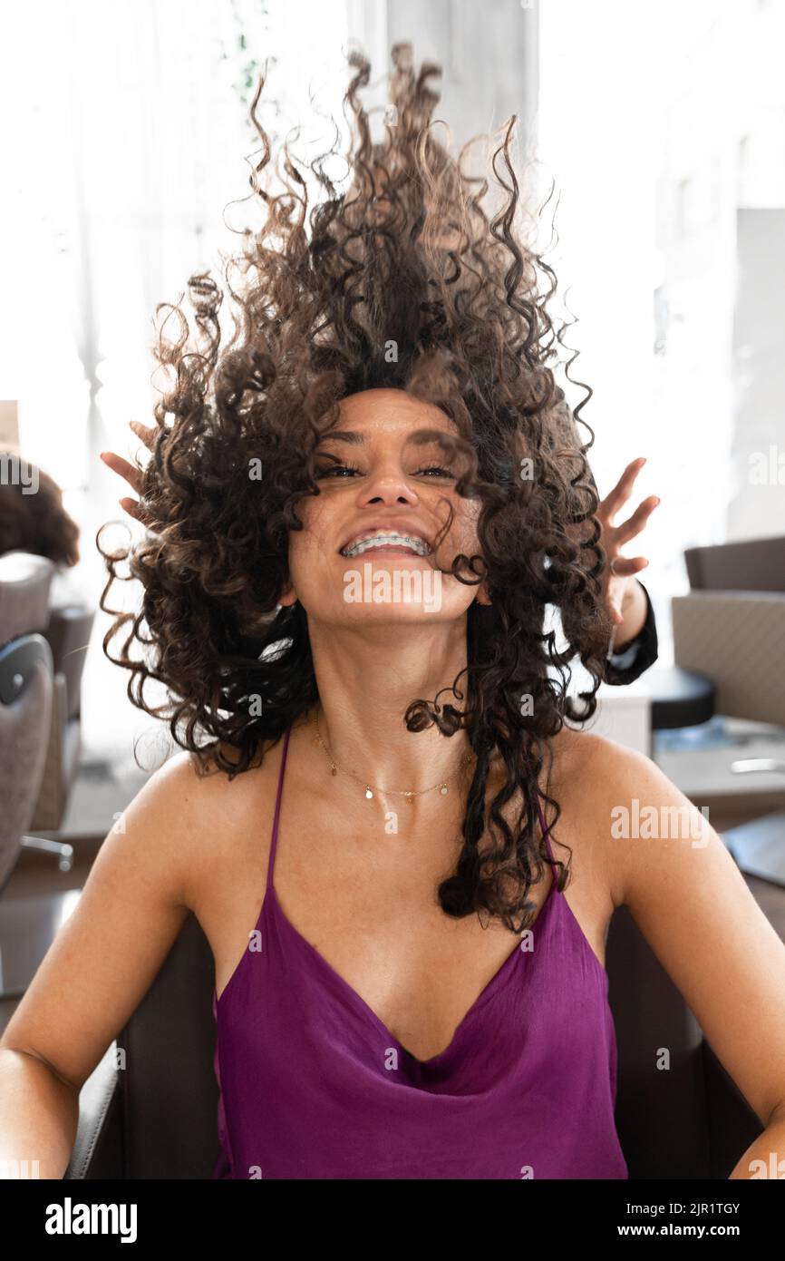 Vertical motion photo of a woman waving her hair in a hairdresser salon ...
