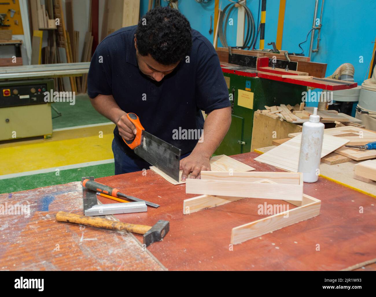 Carpenter man using wood hand saw Stock Photo - Alamy