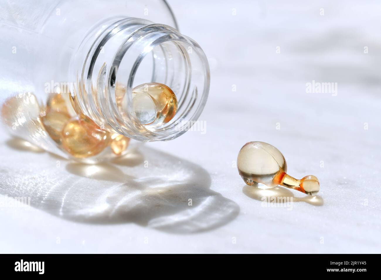 Serum capsules in petri dish for healthy skin, close-up on off white ...