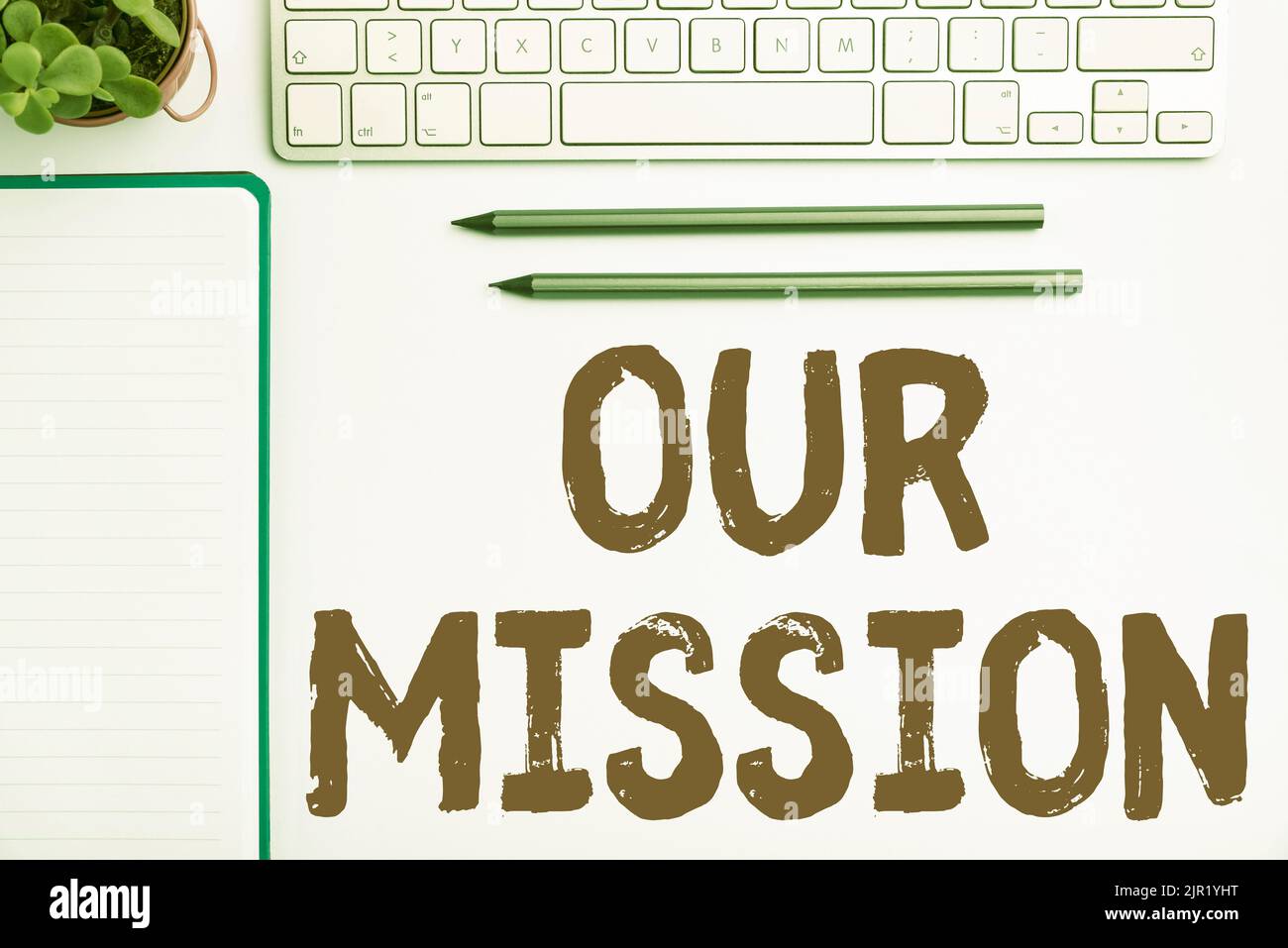 An OUR MISSION text on white background with computer keyboard, pencils ...