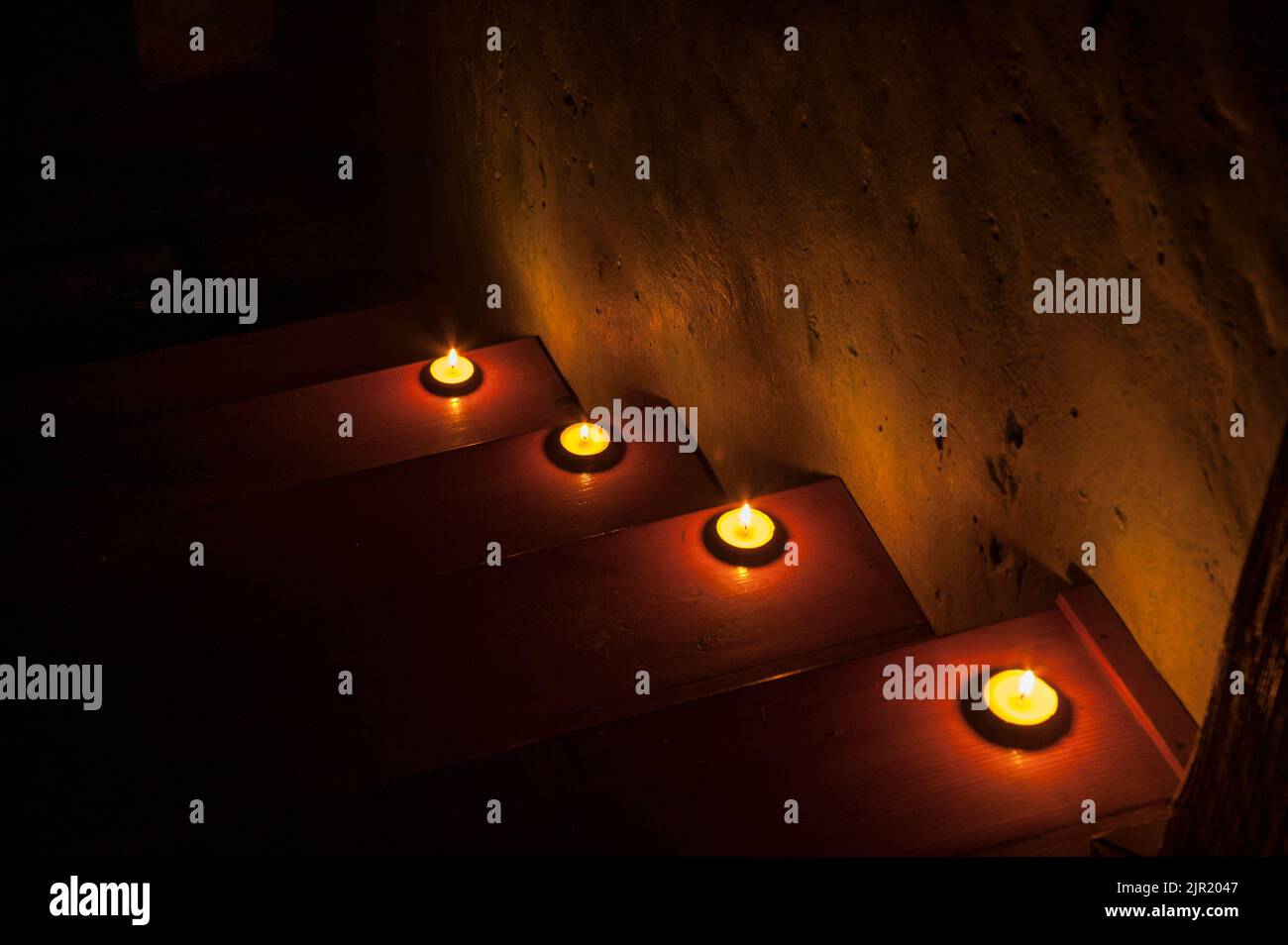 Dark wooden staircase illuminated by candles. Get down to the unknown ...