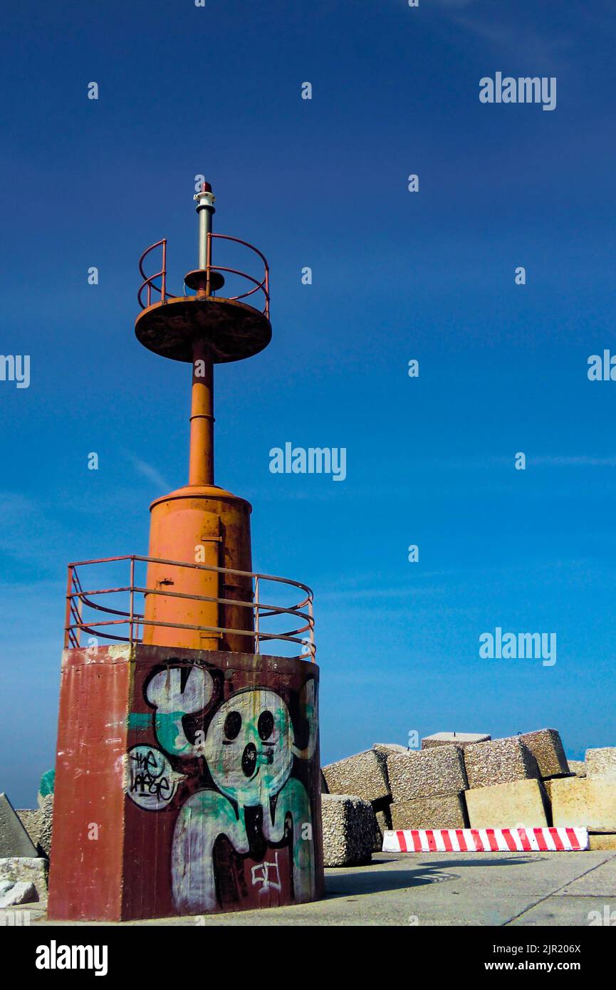 A red lighthouse vandalized by graffiti in a blue landscape and crystal ...