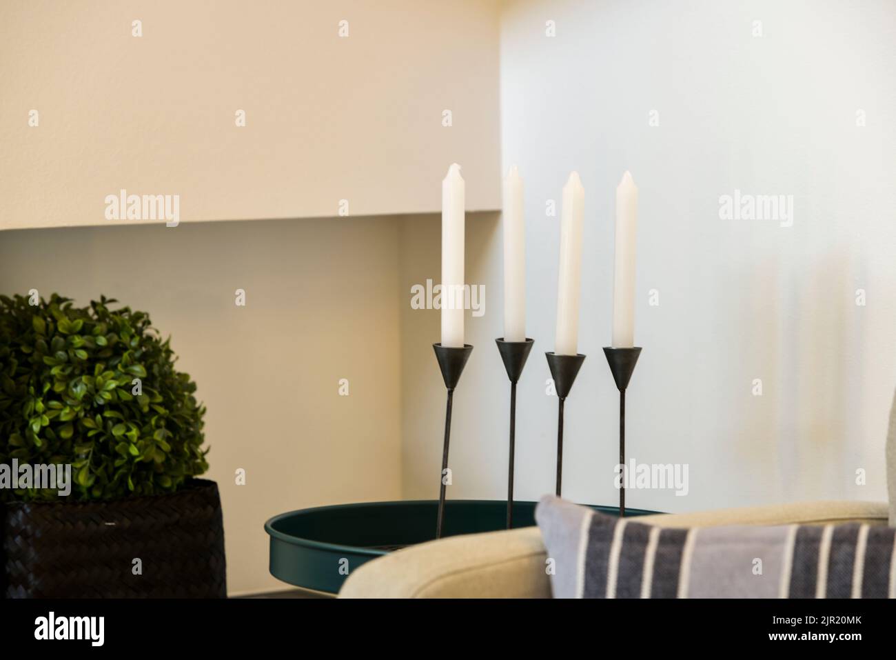 Corner of a room with black candle holders with white candles on a ...