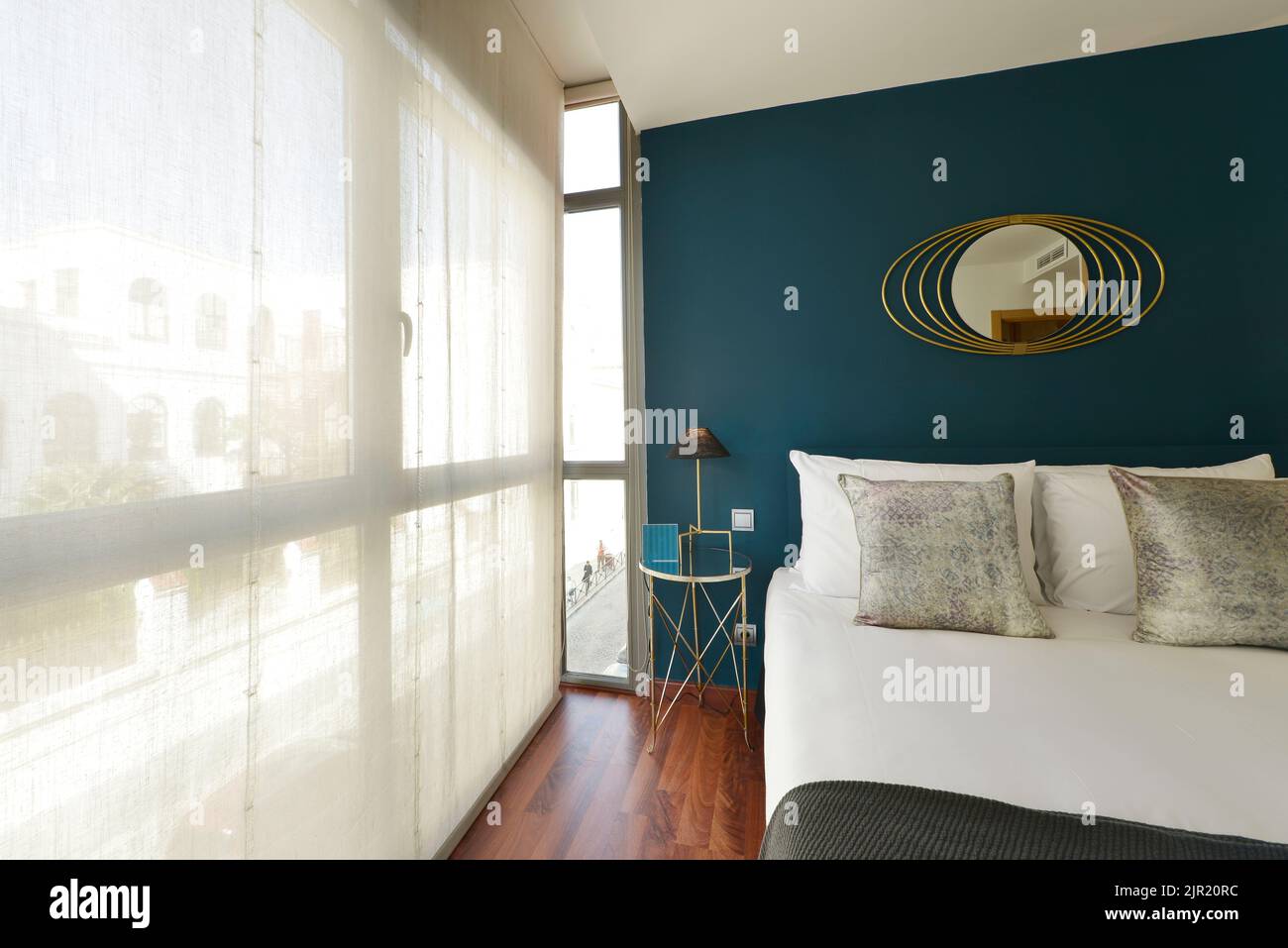 Bedroom with double bed with bright gray cushions, indigo blue wall ...