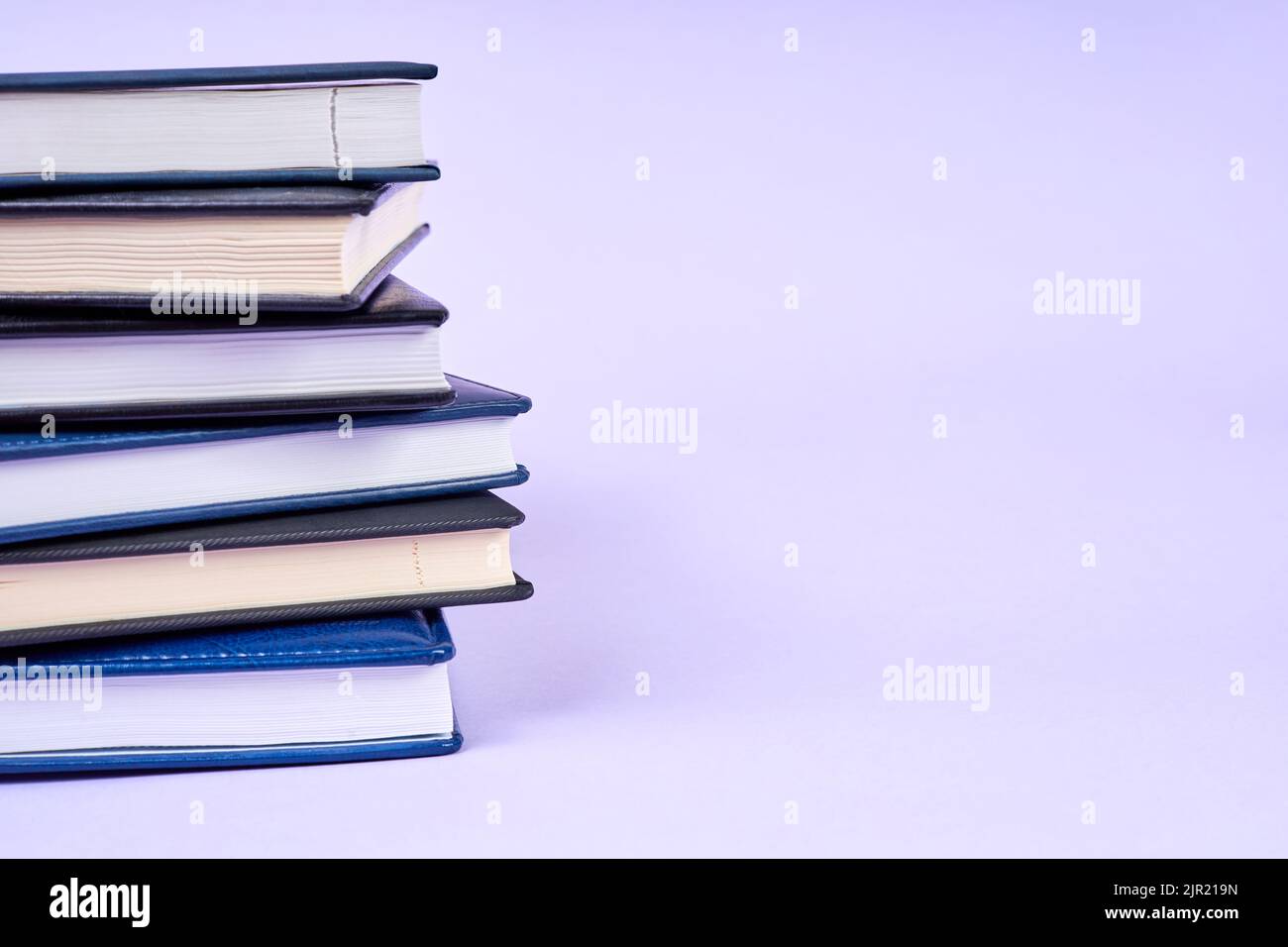 Stack of office notepads on purple background Stock Photo - Alamy