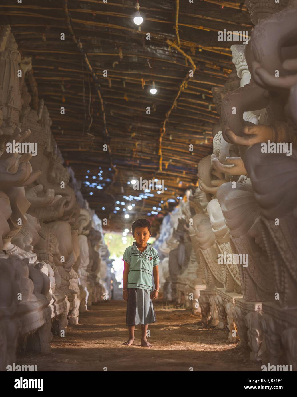 Pileru, India - July 28,2022: Kid standing between ganesha idols in ...