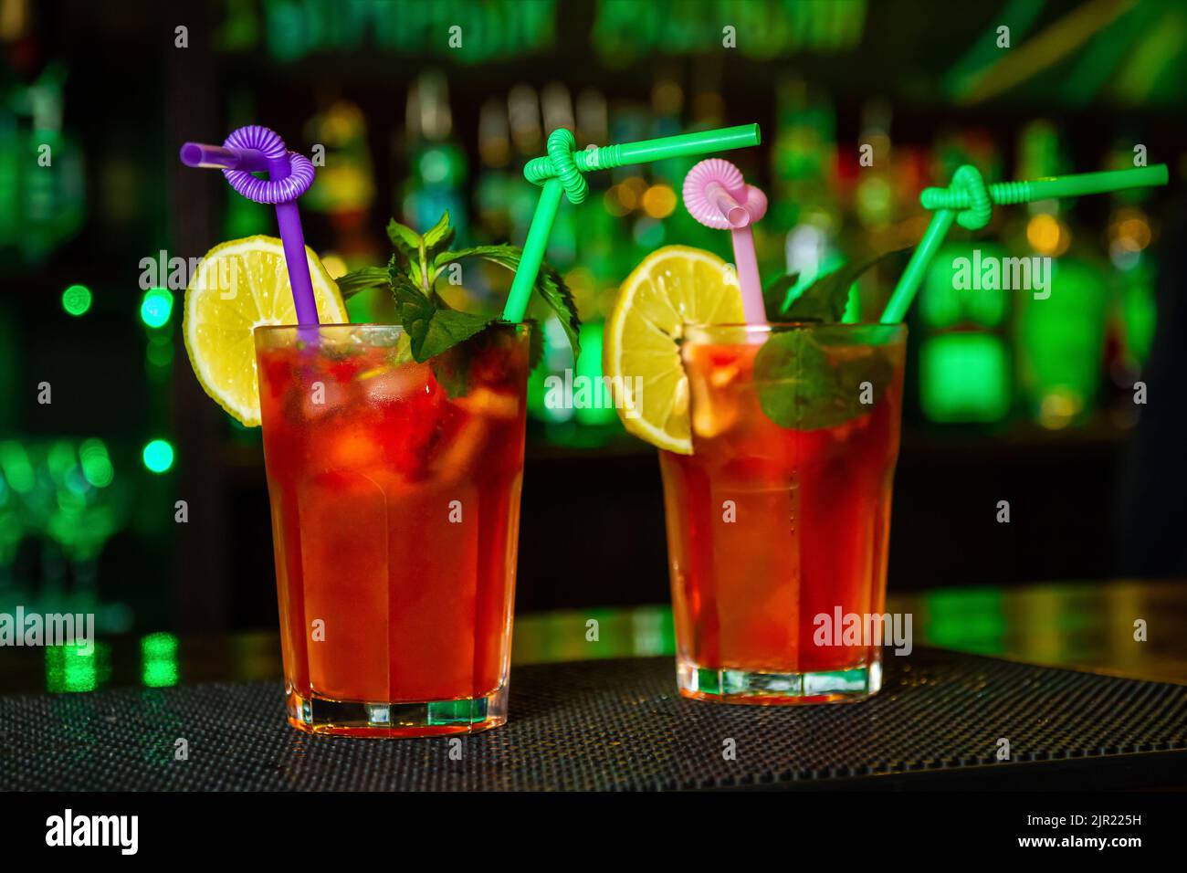 Red Alcoholic cocktails decorated with slices of lemon on the bar ...