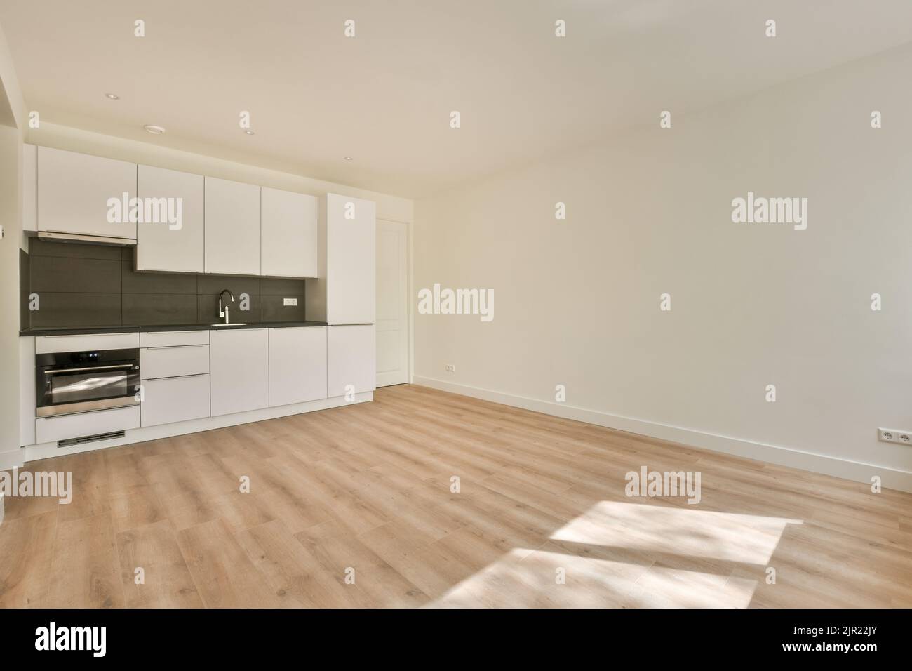 Interior of empty white kitchen with windows and wooden parquet floor ...