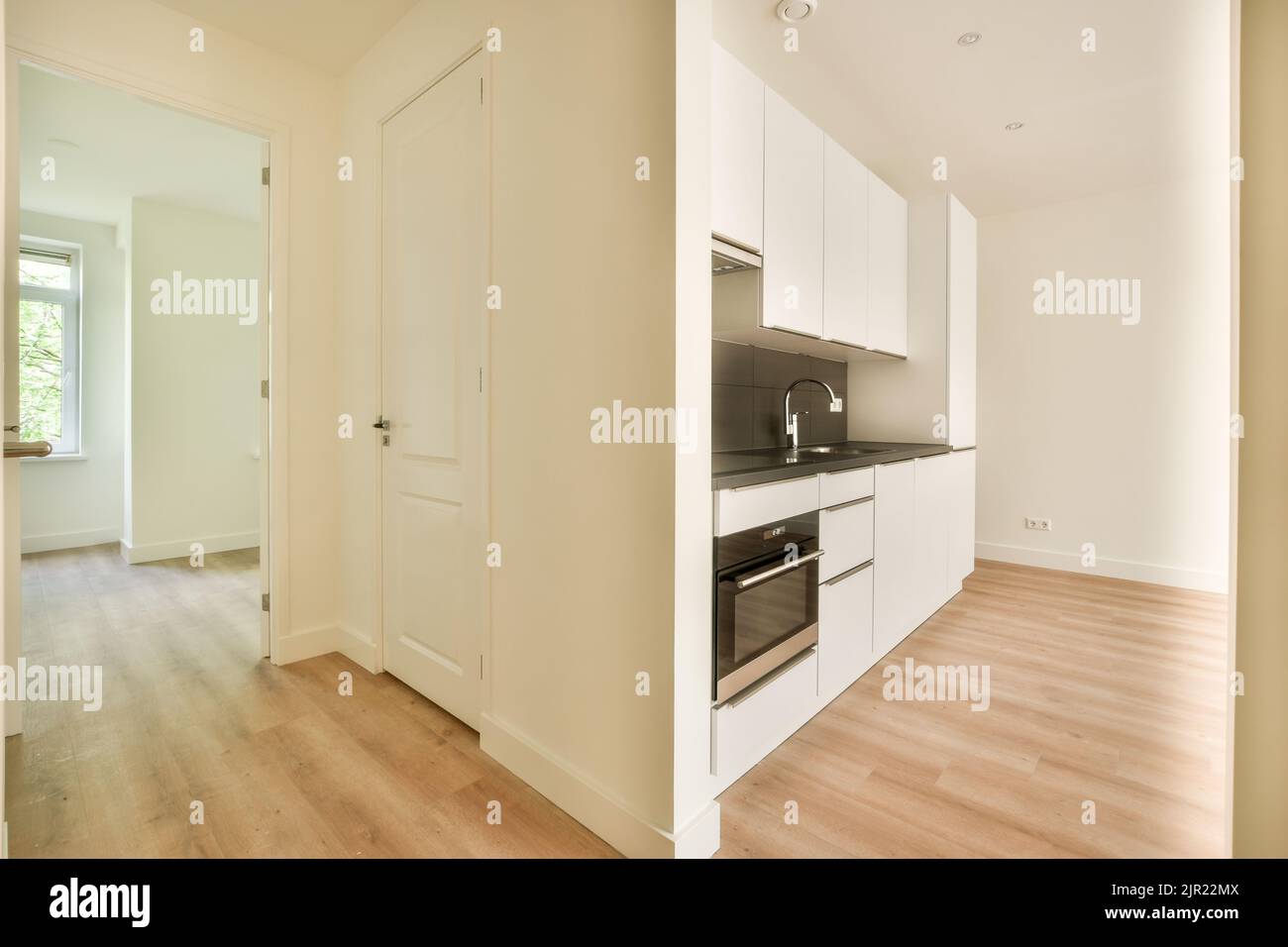 Interior of empty white kitchen with windows and wooden parquet floor ...