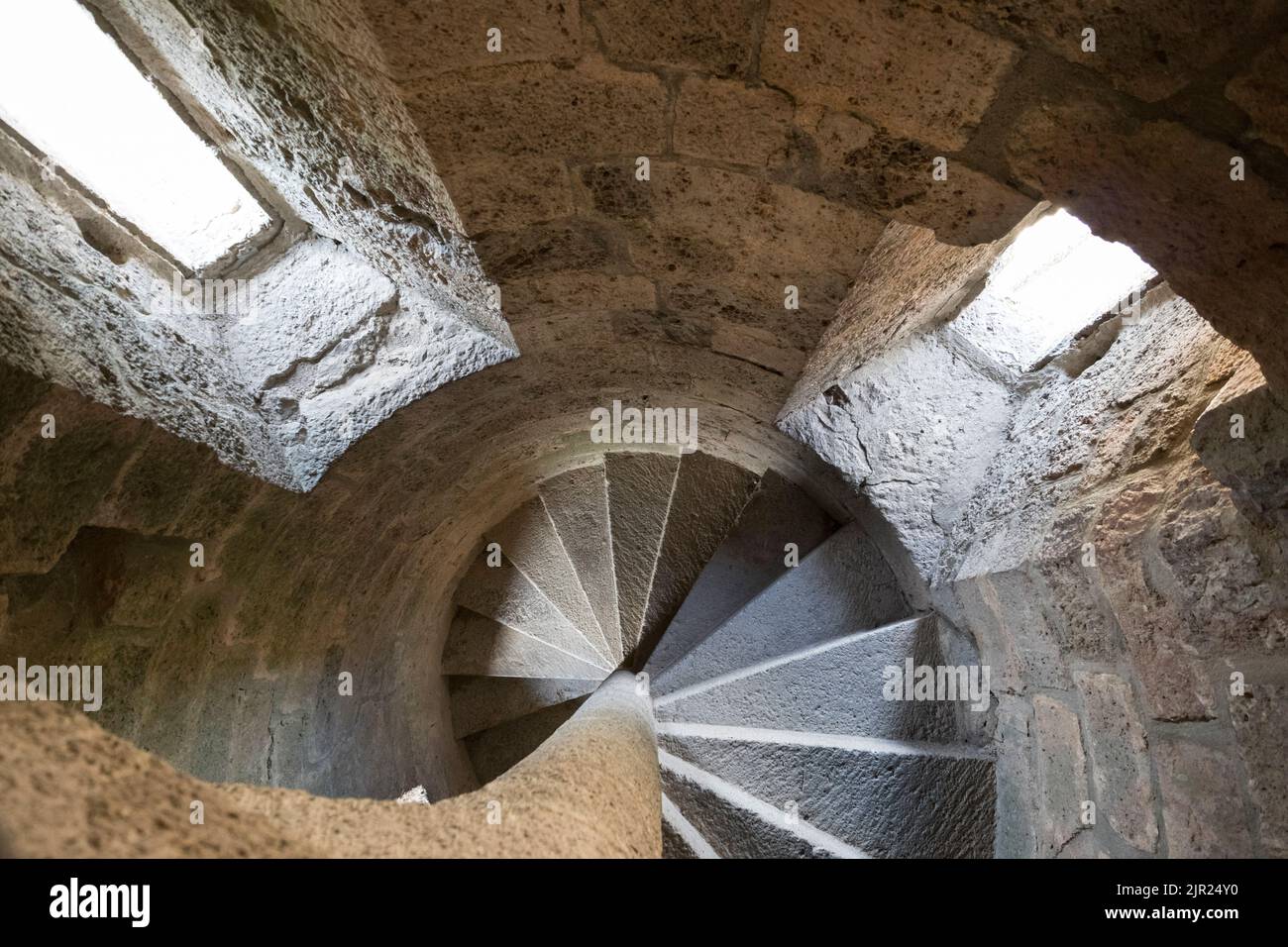 Spiral Stone Staircase Illuminated by Light Spilling through Windows ...