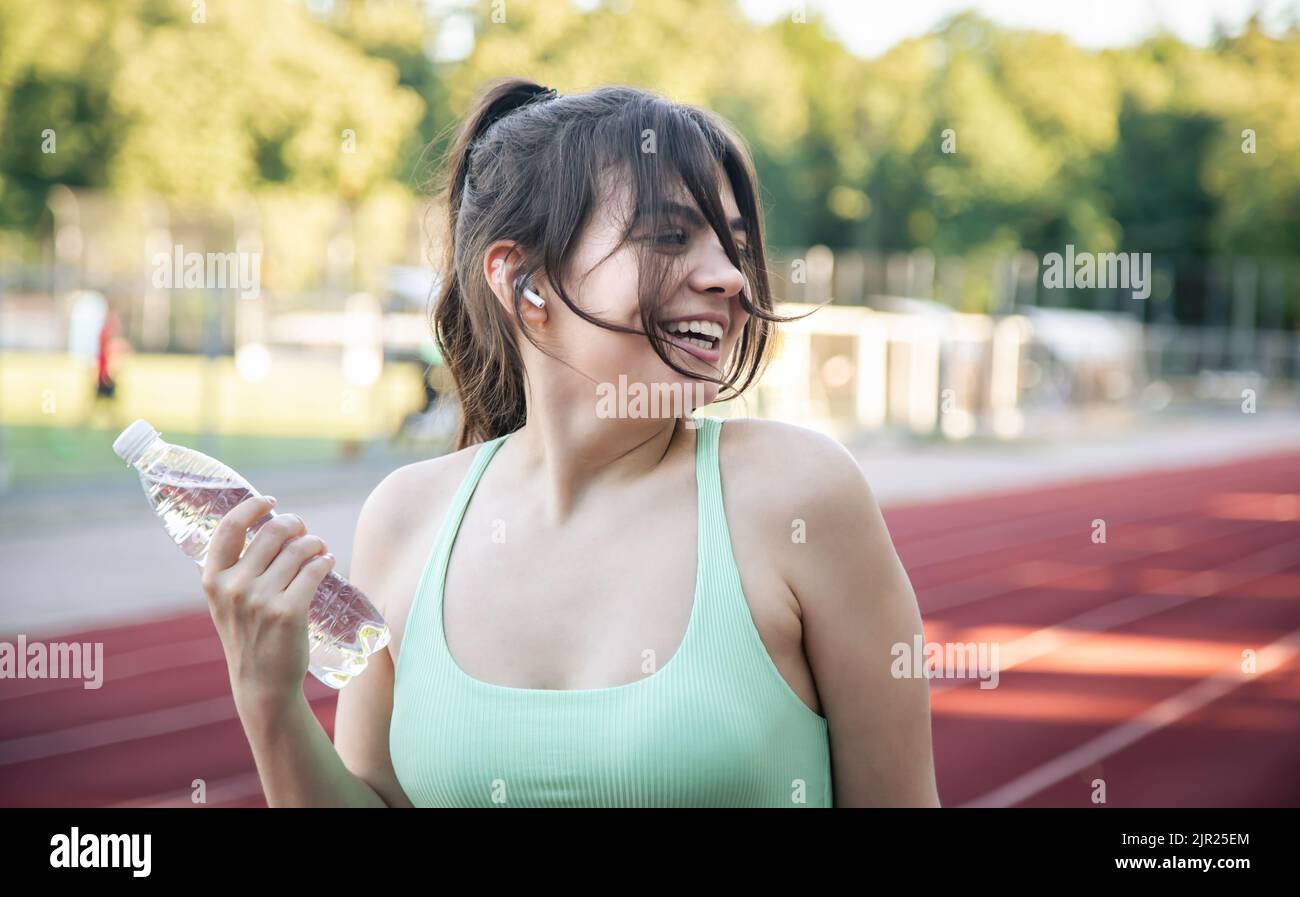 A young woman with a bottle of water in training at the stadium Stock ...