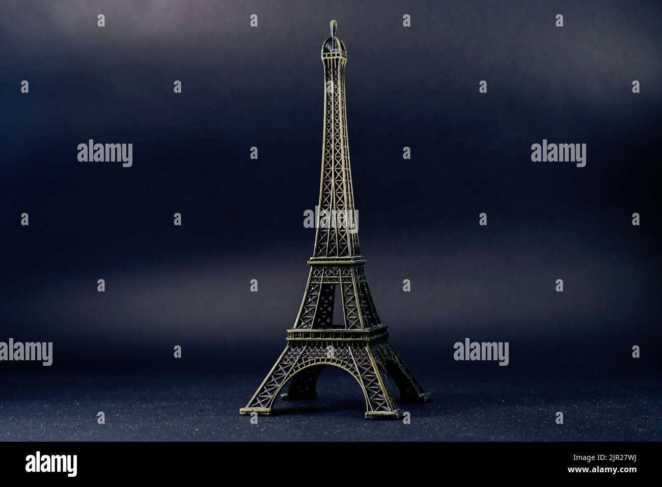 A closeup of a metal miniature of the Eiffel Tower in a homemade studio ...